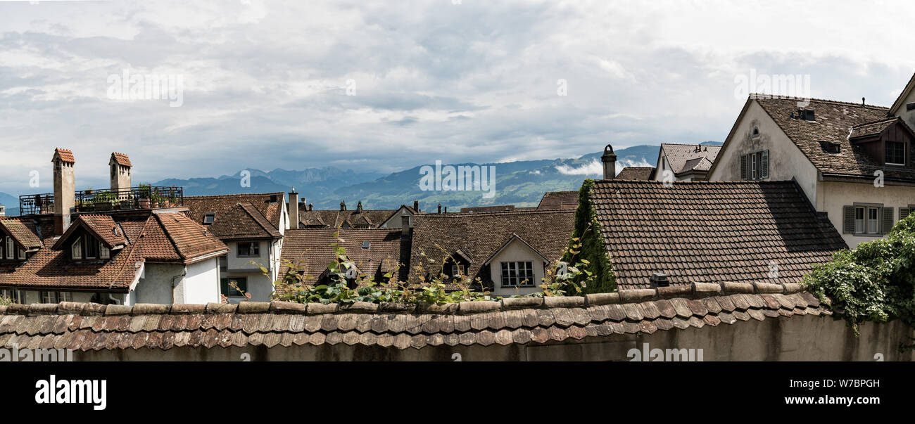 A panorama view of old houses and rooftops in Europe with mountain ...