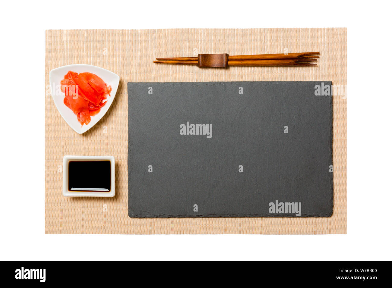 Empty rectangular black slate plate with chopsticks for sushi, ginger ...