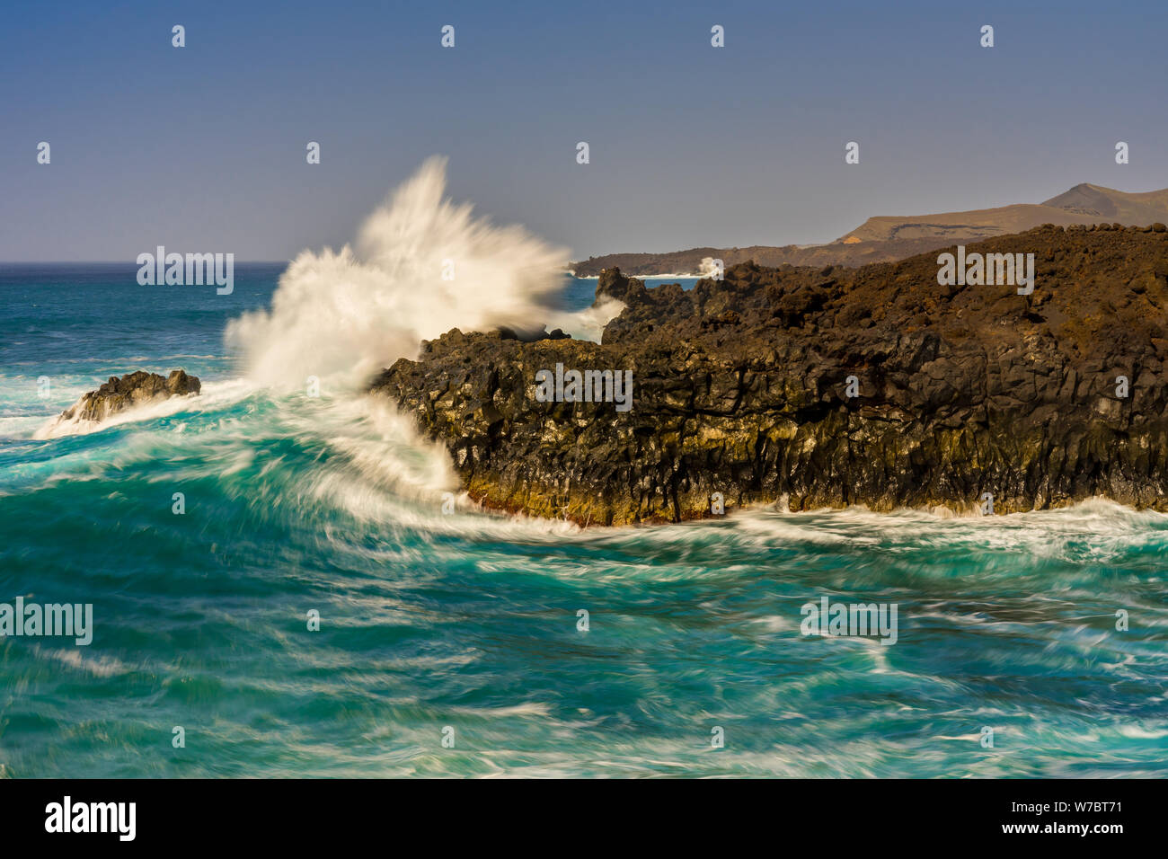 Spain, Lanzarote, Huge wave breaking into spindrift at lava rocks of ...