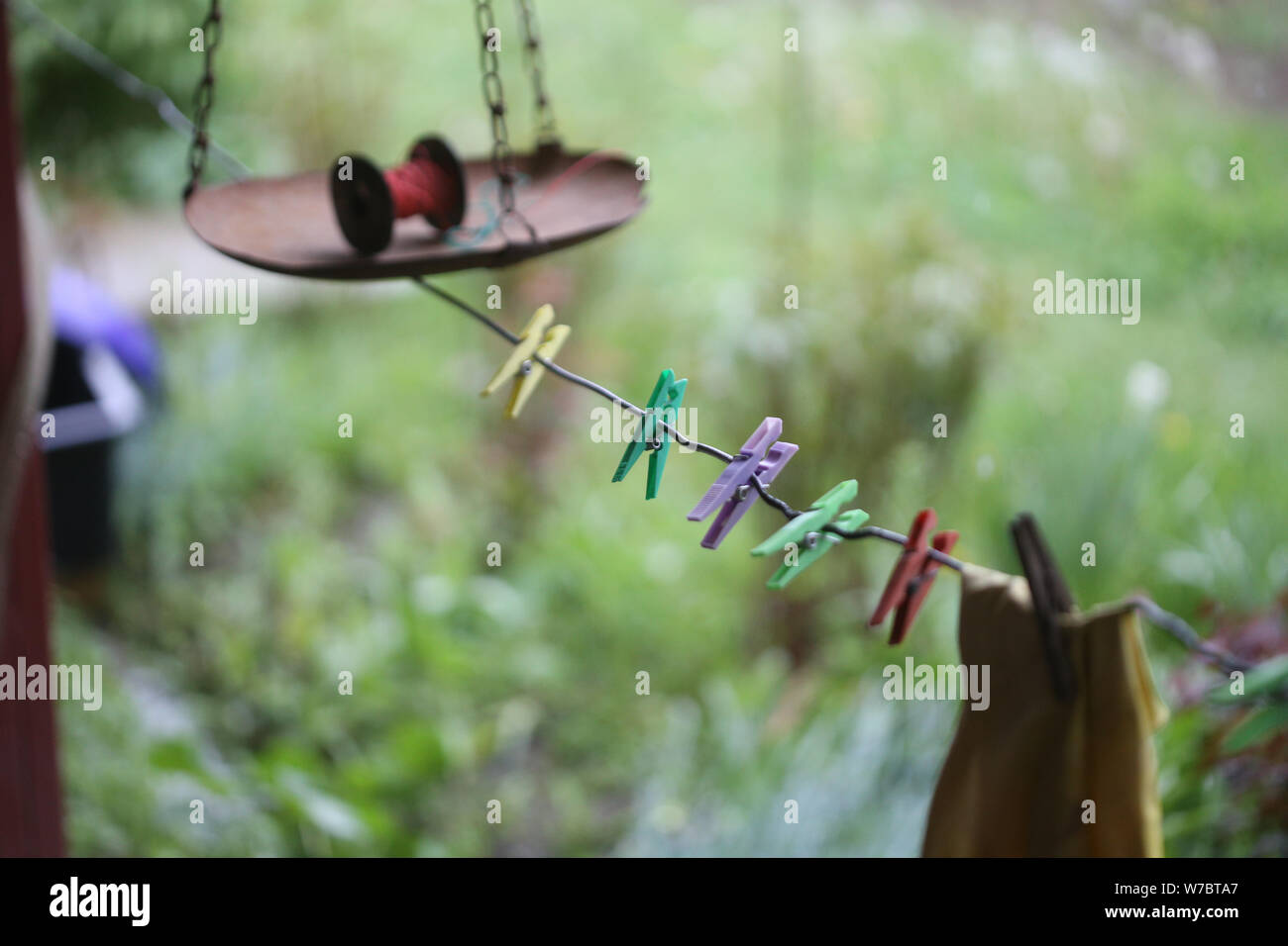 Plastic clothes pegs on a wire Stock Photo - Alamy