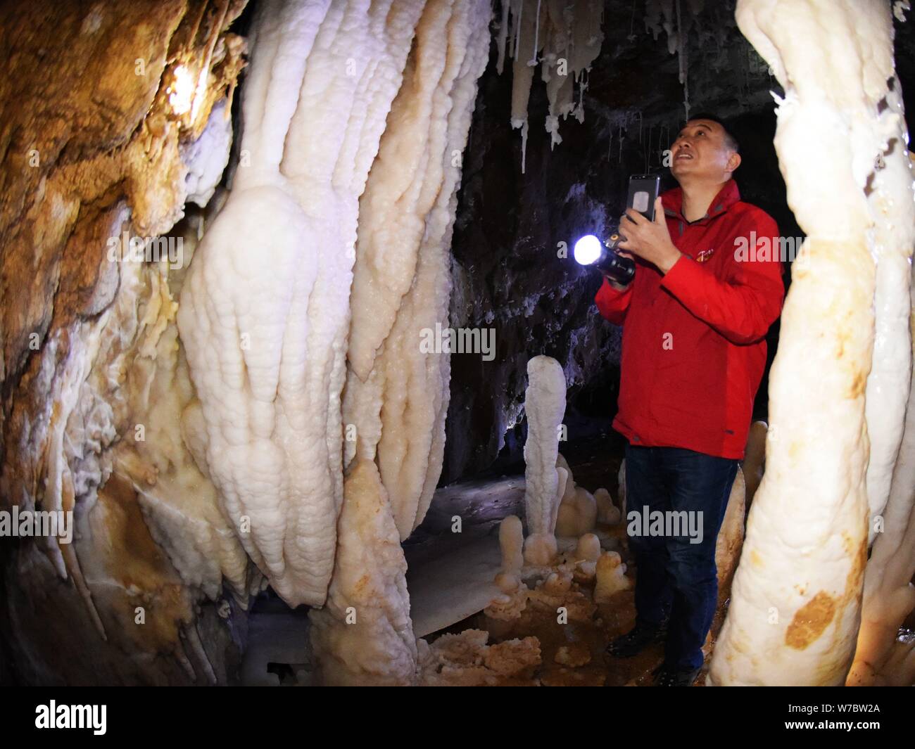 A visitor views the snow-white stalactites and stalagmites in the Snow ...
