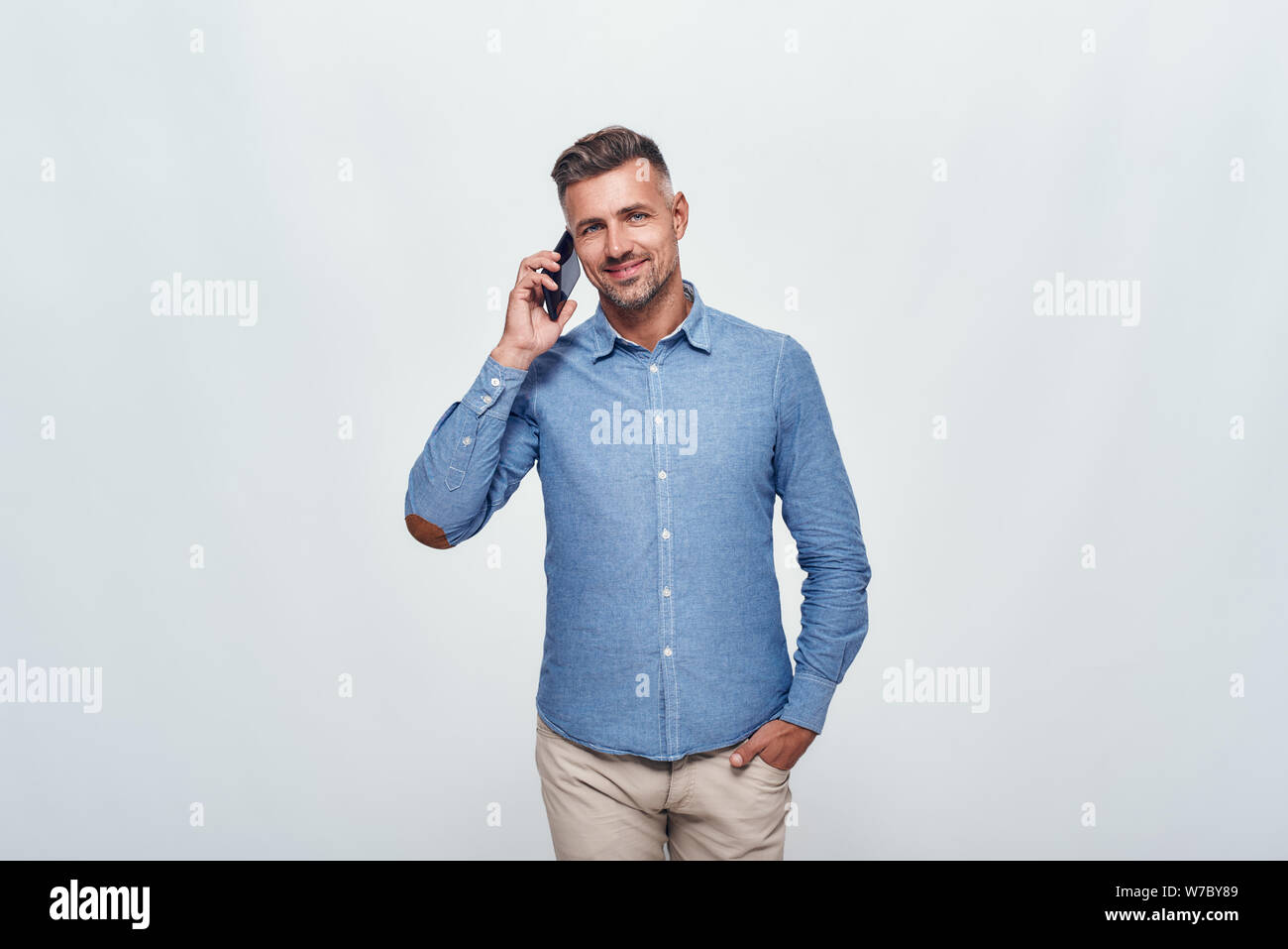 Good talk. Handsome bearded man in casual wear talking on the phone and ...