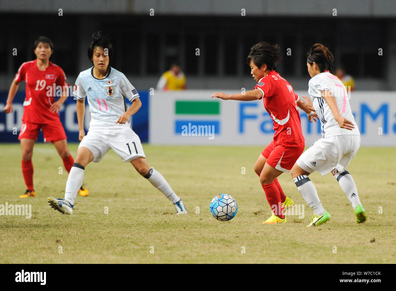 Sung Hyang Simj, right, of DPR of Korea kicks the ball to make a pass ...