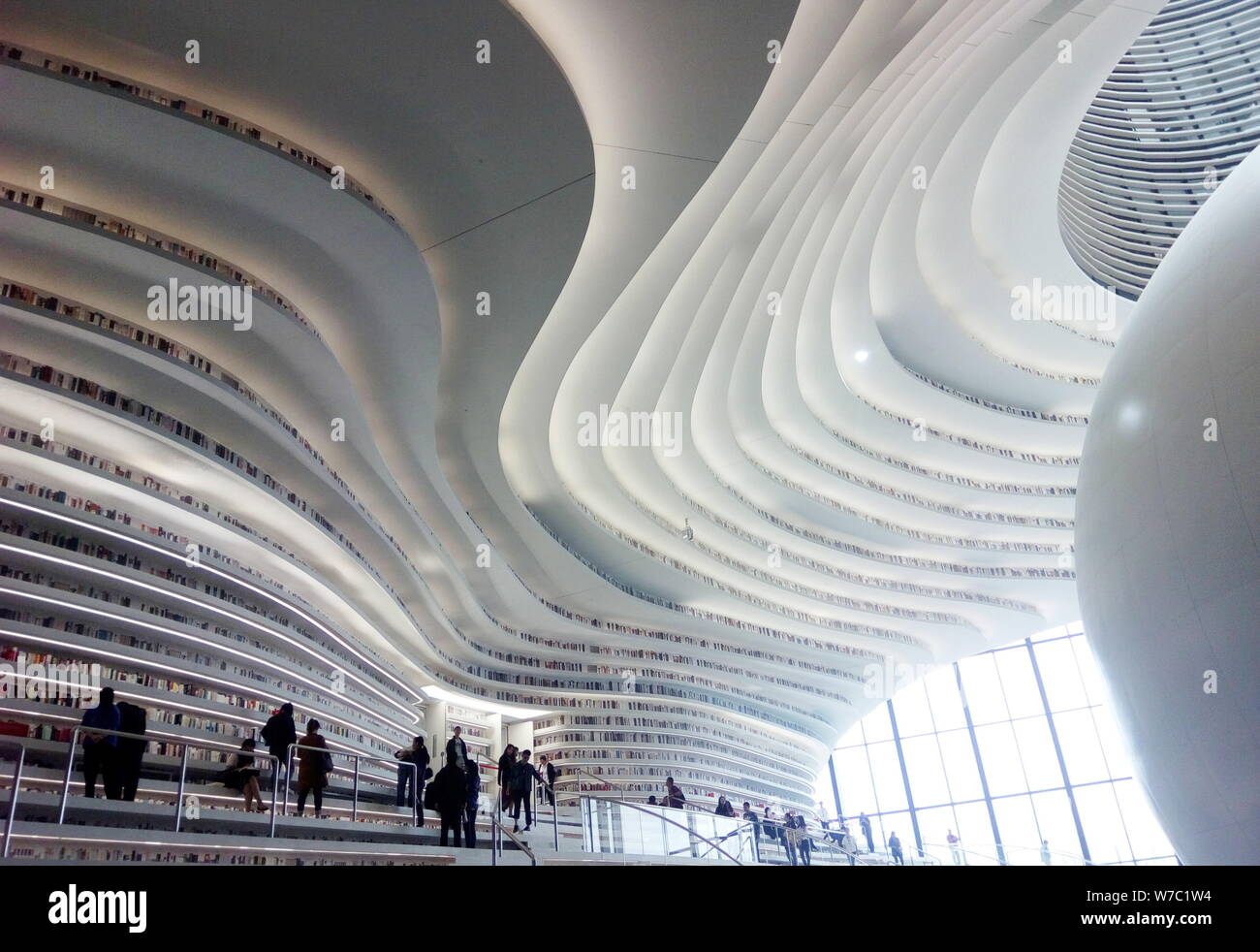 --FILE--People visit the Tianjin Binhai Library which displays a large ...