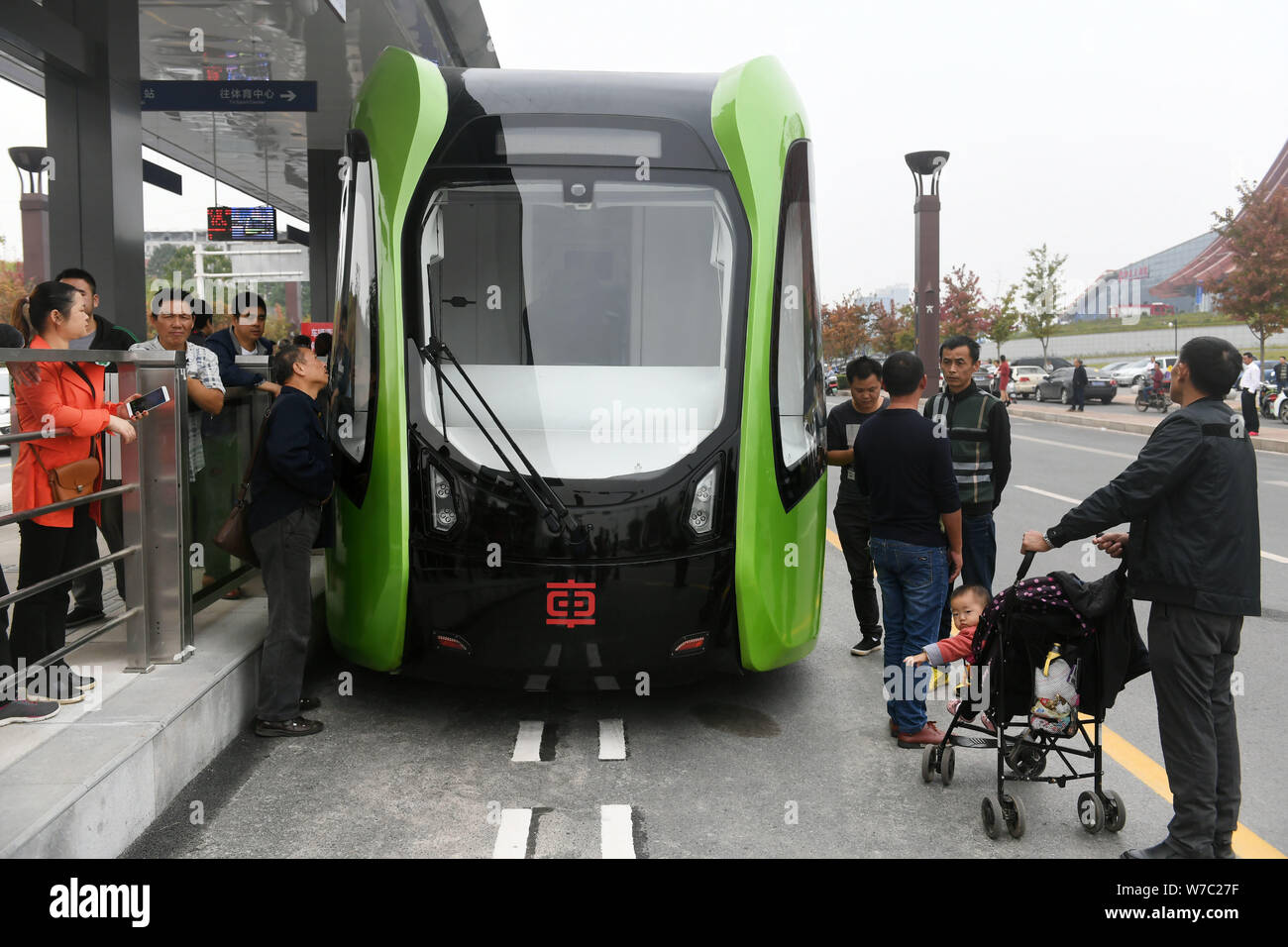 Passengers queue up to take a ride on a railless train, developed by ...