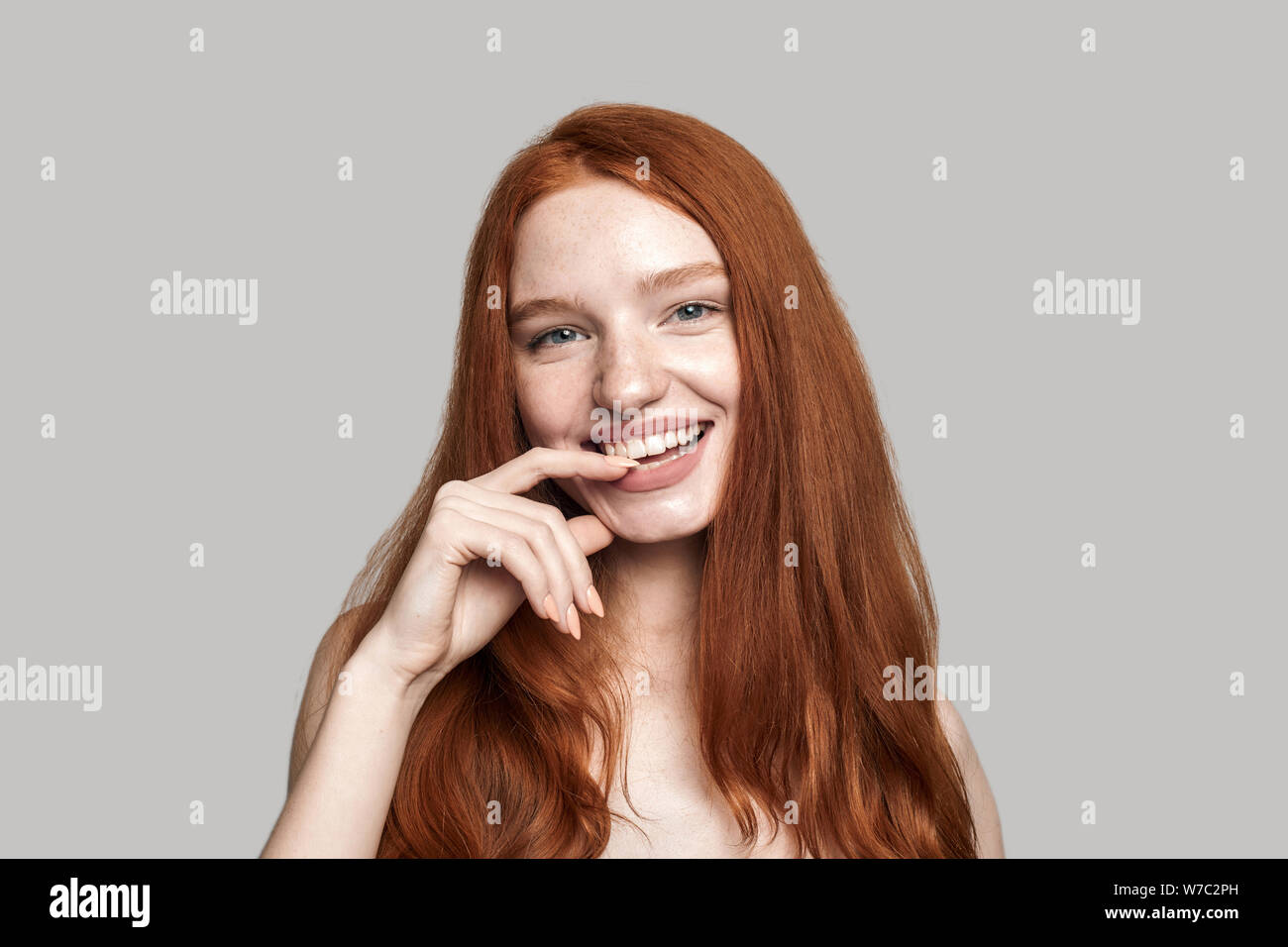 Living with smile. Studio shot of cheerful pretty young redhead lady ...