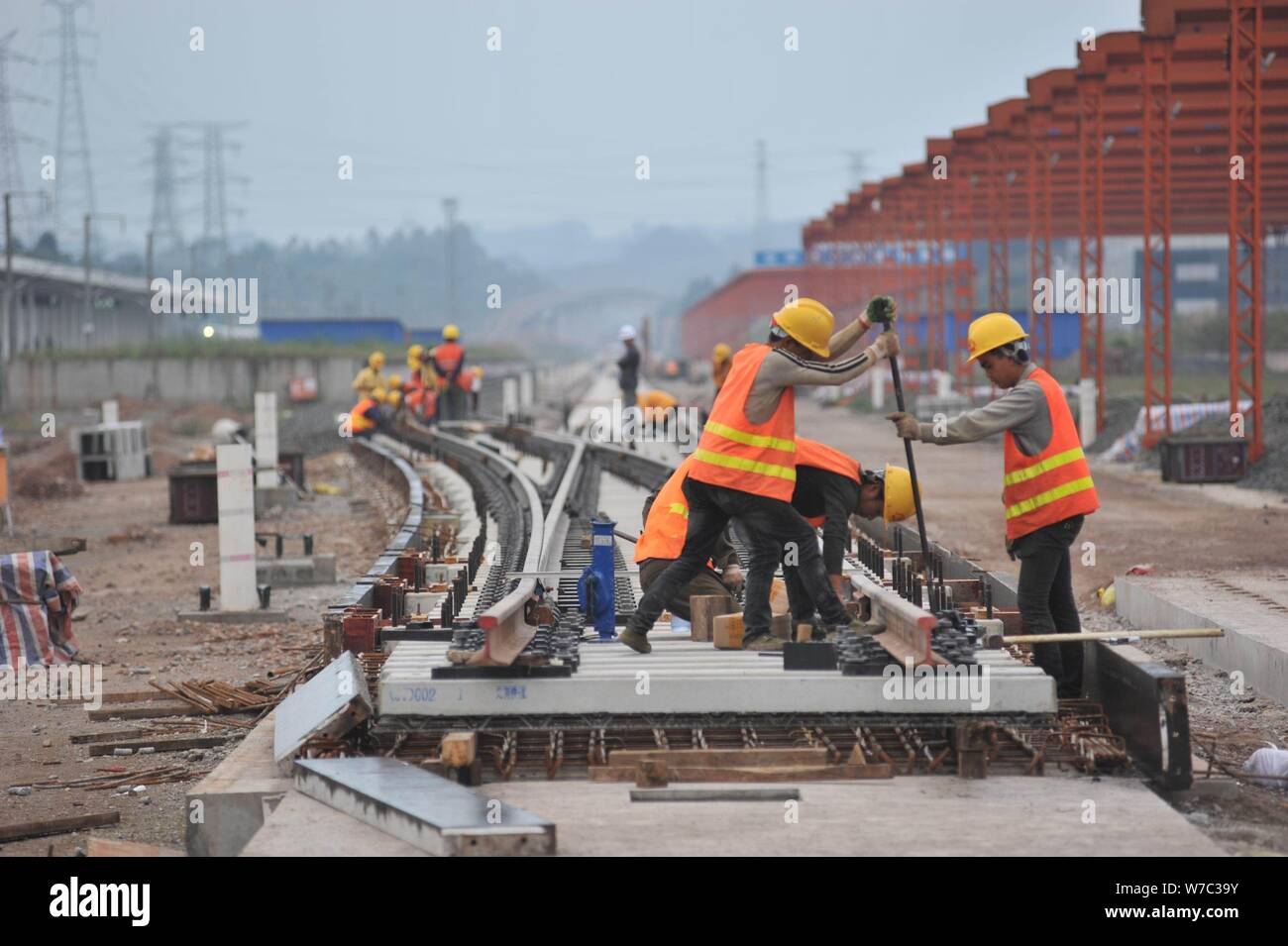 Chinese workers labor on the ballastless track at the construction site ...