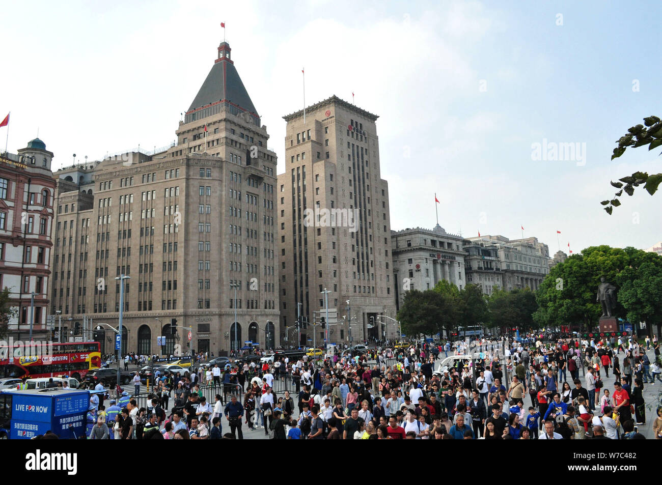 Tourists crowd the promenade on the Bund along the Huangpu River during ...