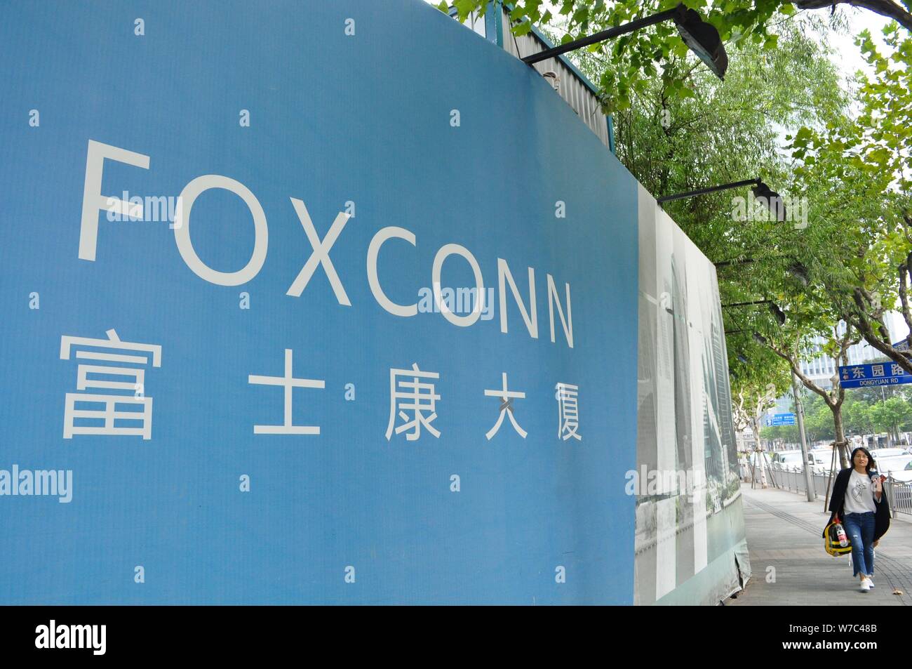 --FILE--A pedestrian walks past the Foxconn headquarters building under ...