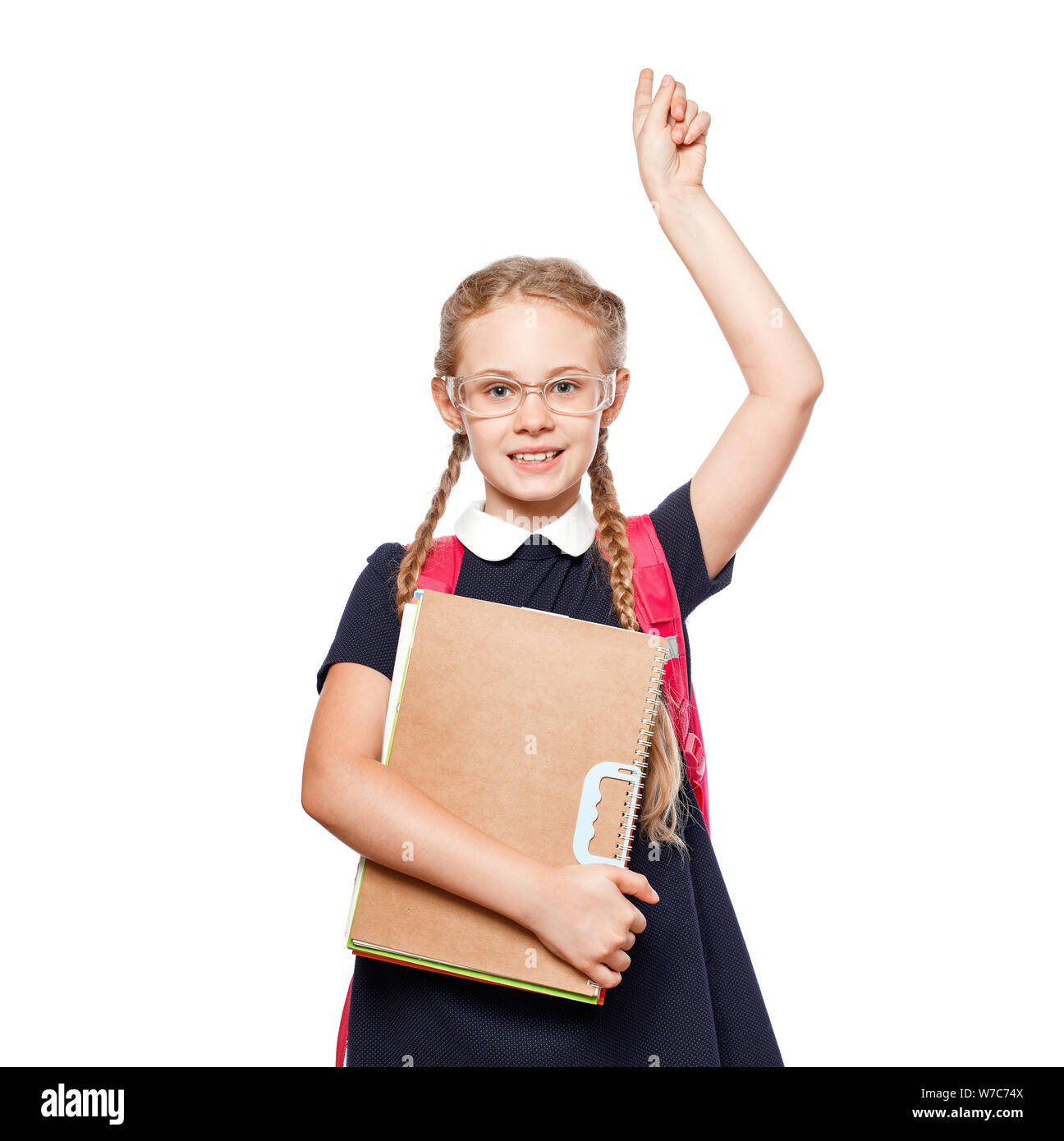 Cheerful 8 years old schoolgirl with backpack wearing uniform standing ...