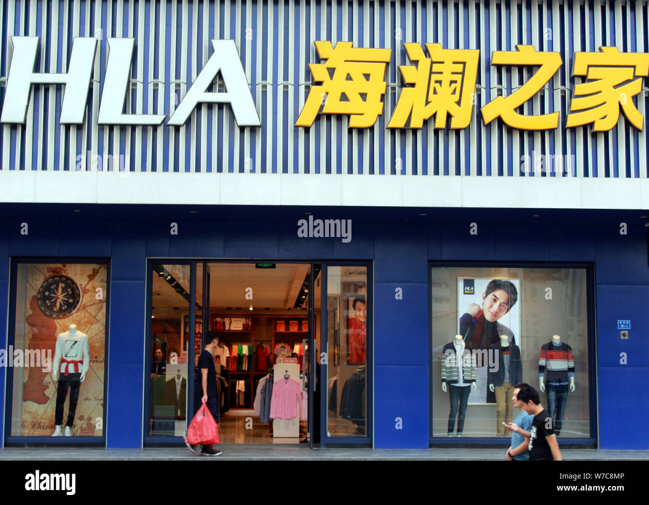 --FILE--Chinese pedestrians walk past a store of fast fashion brand ...