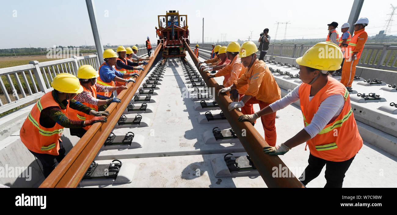 --FILE--Chinese workers lay tracks of the Qingdao¨CJinan High-Speed ...
