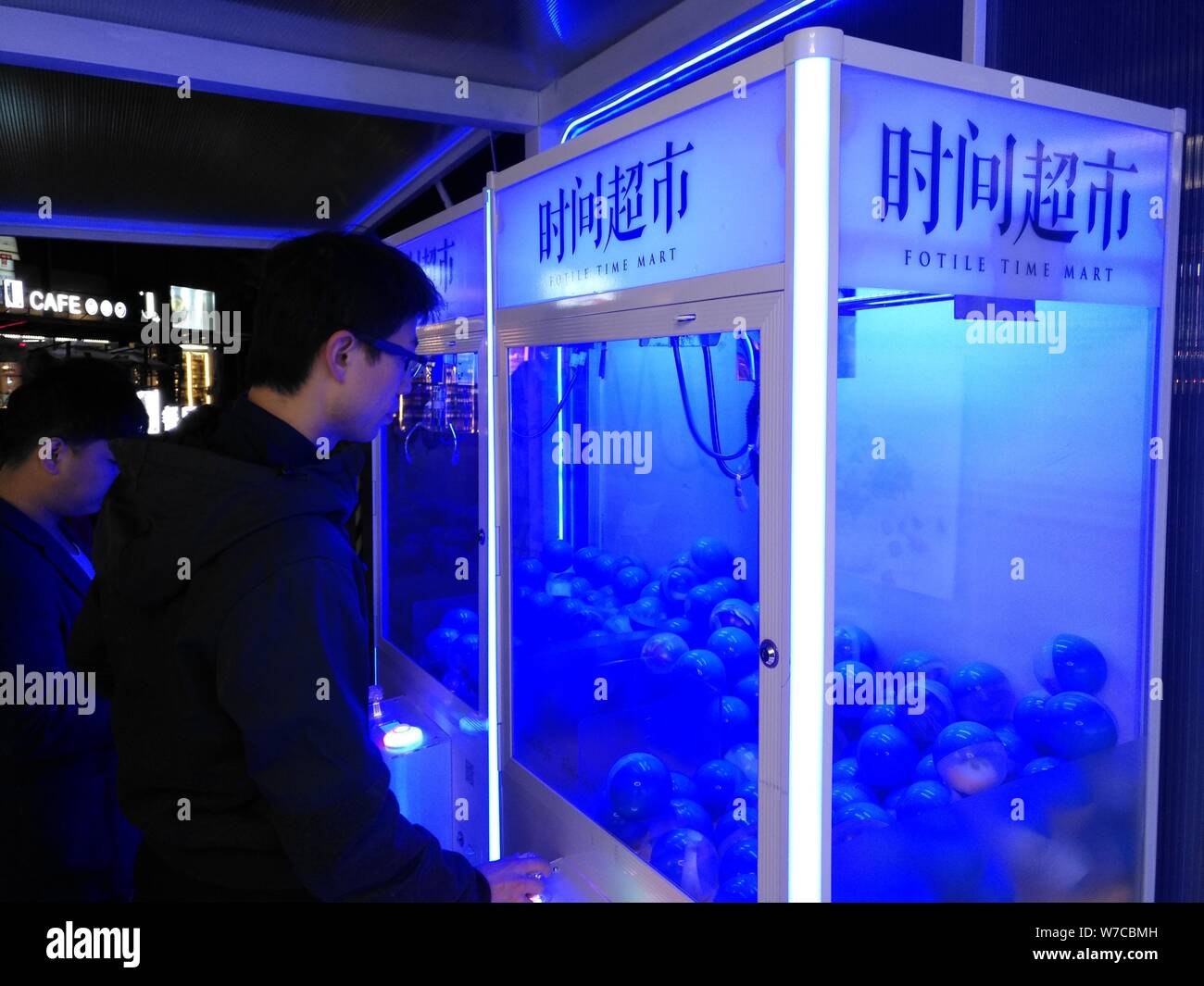 Customers get time capsules from a grabbing machine in the Fotile Time ...