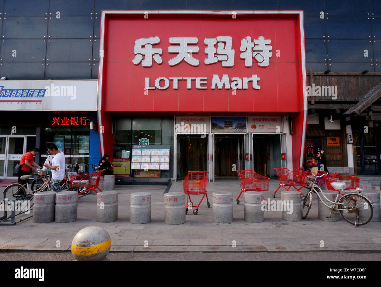 --FILE--Local residents walk past a Lotte Mart of Lotte Group in ...