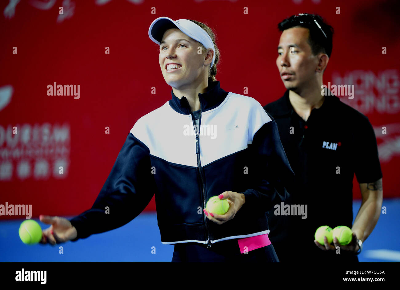 Danish tennis player Caroline Wozniacki throws tennis balls with her ...