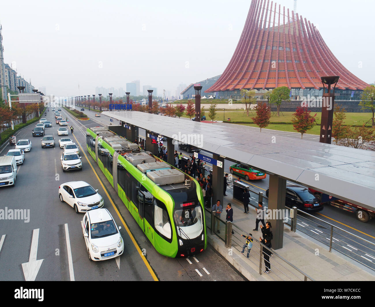 Passengers queue up to take a ride on a railless train, developed by ...