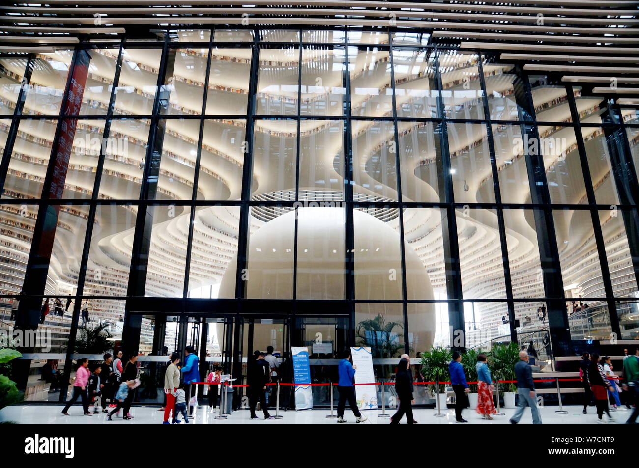--FILE--People visit the Tianjin Binhai Library which displays a large ...