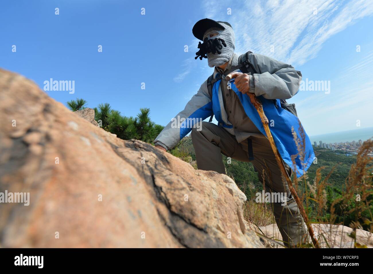 A female Chinese climber wearing an autumn and winter facekini poses on ...