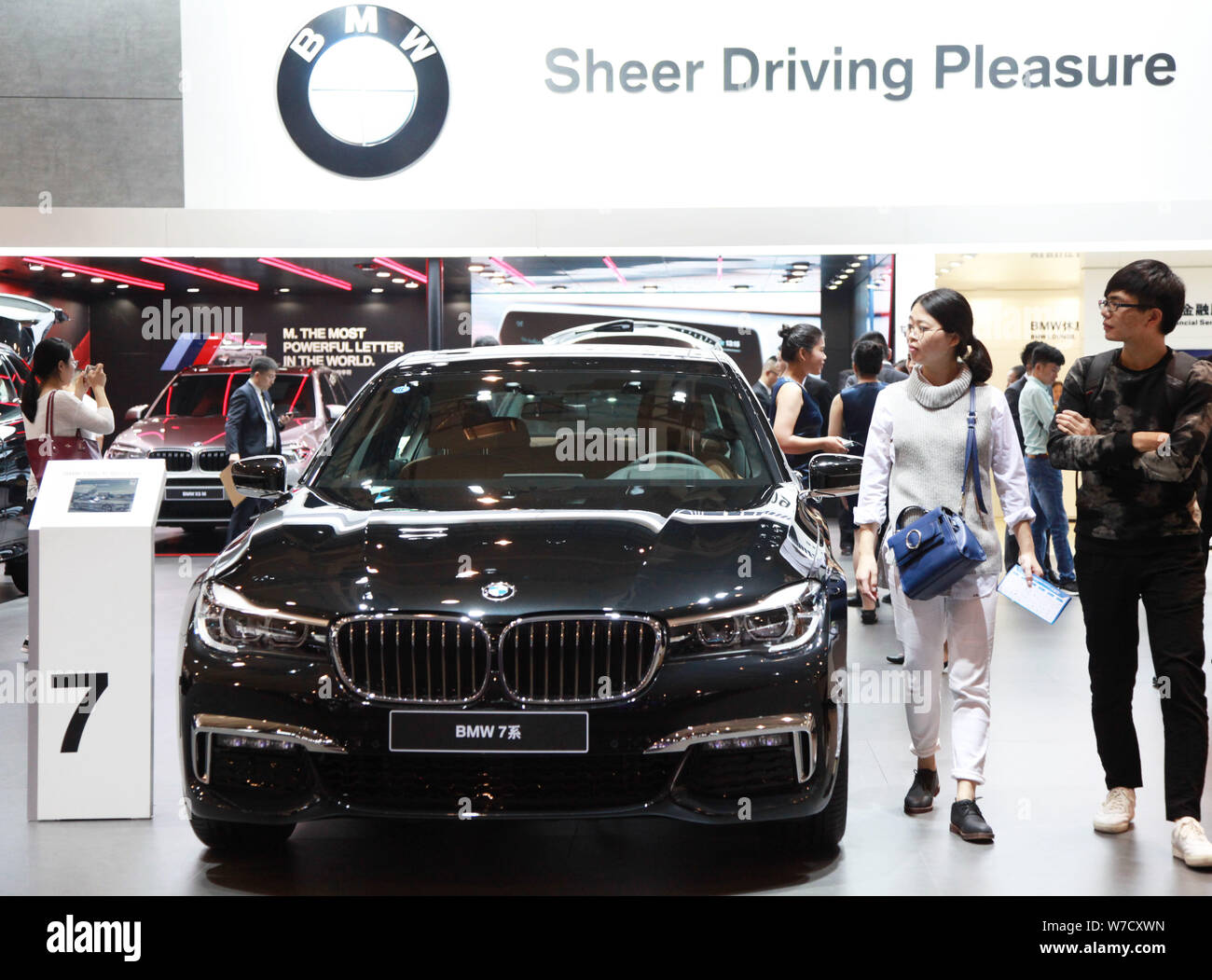 --FILE--People look at a BMW 7 Series car on display at the stand of ...