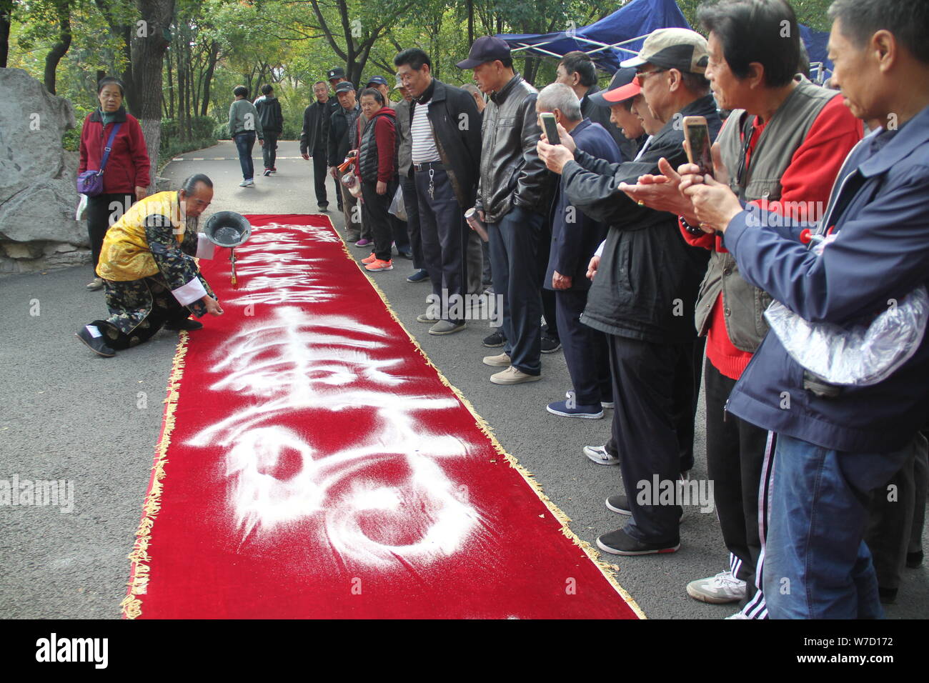 An elderly man uses a bowl of salt to write a 9-meter-long Chinese ...