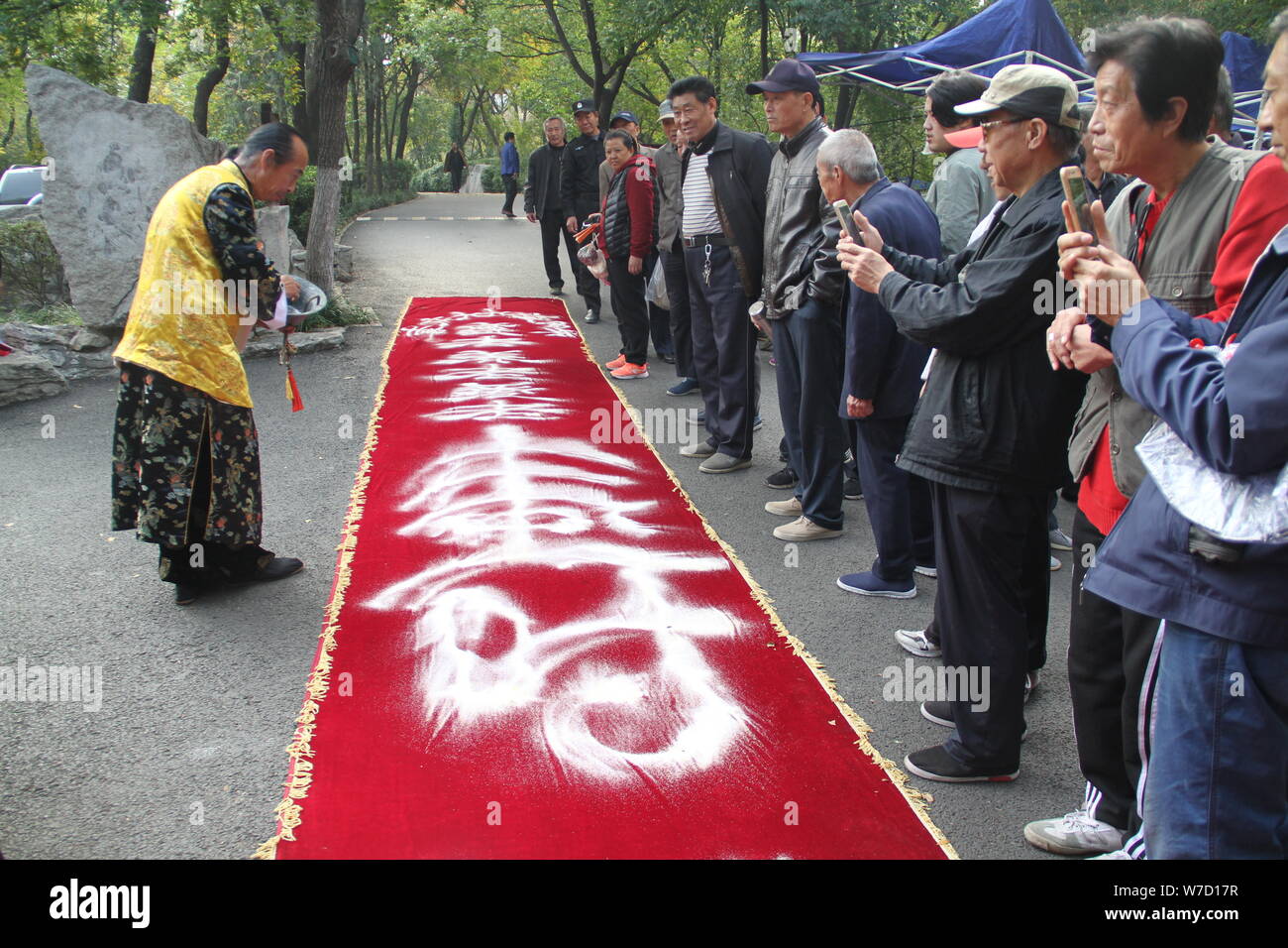 An elderly man uses a bowl of salt to write a 9-meter-long Chinese ...