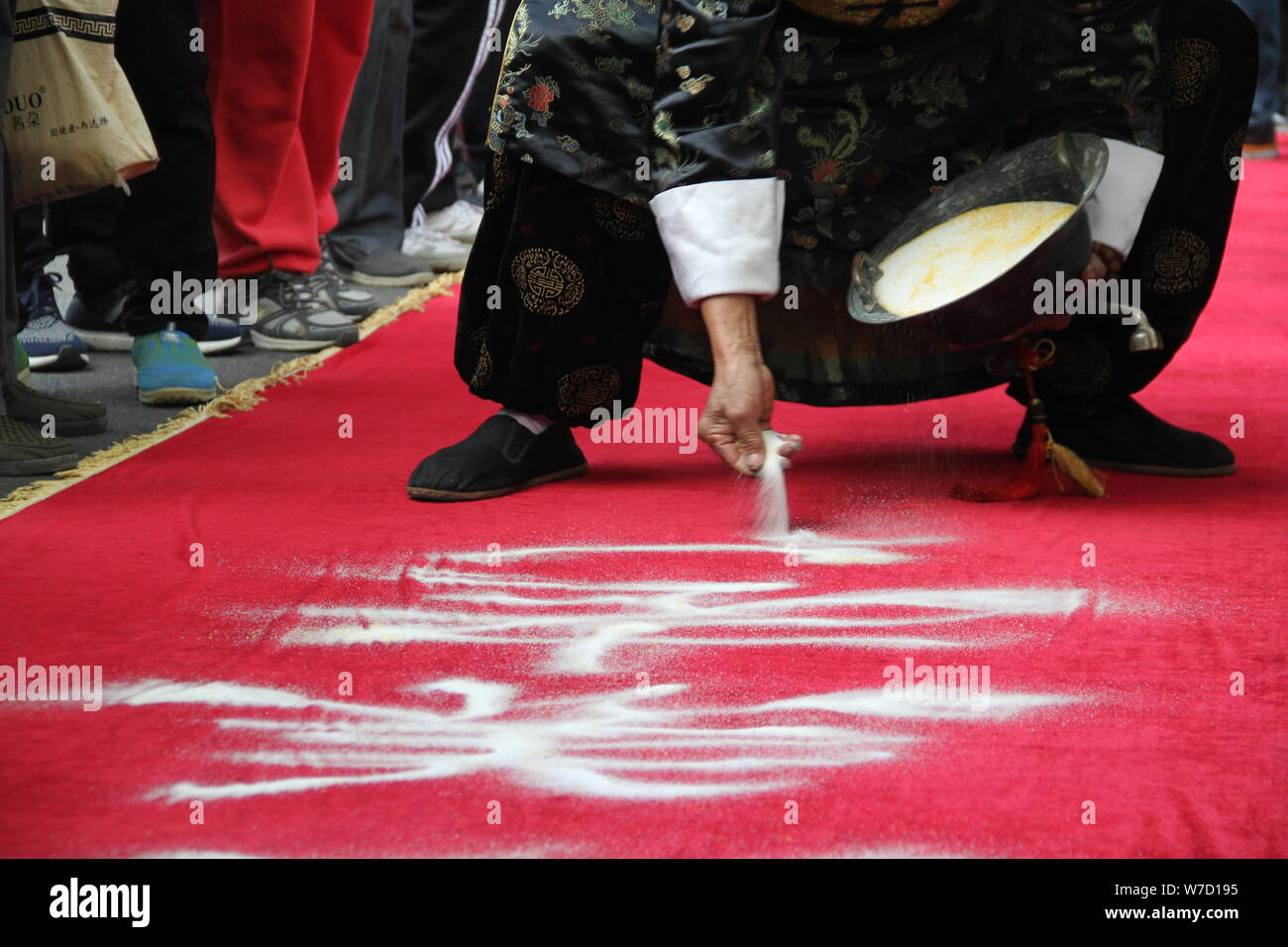 An elderly man uses a bowl of salt to write a 9-meter-long Chinese ...