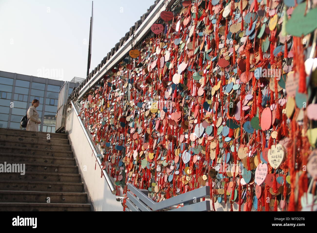 A pedestrian walks past a "love confession" wall covered with lovelocks ...