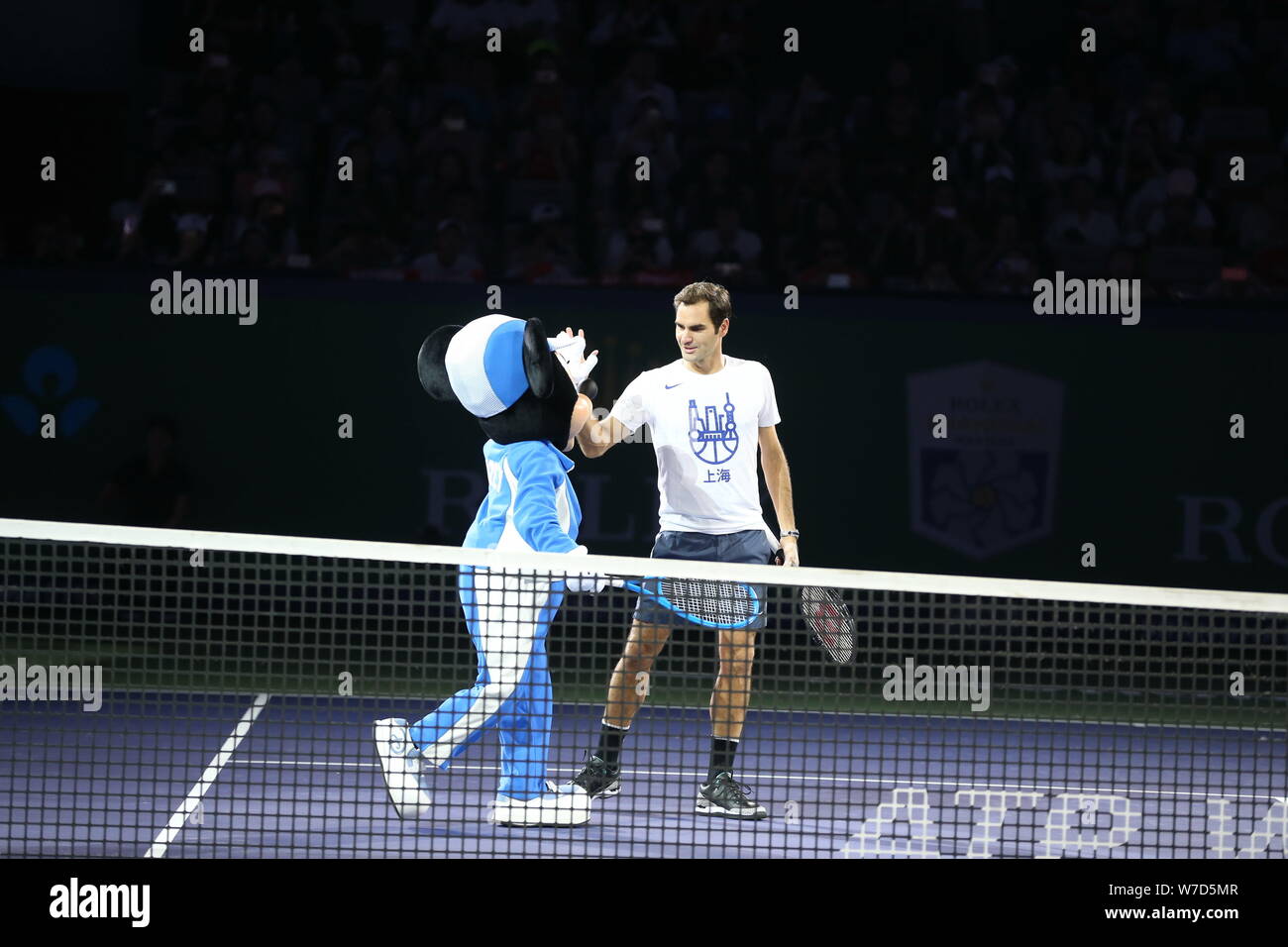 Swiss tennis player Roger Federer interacts with Mickey Mouse during ...