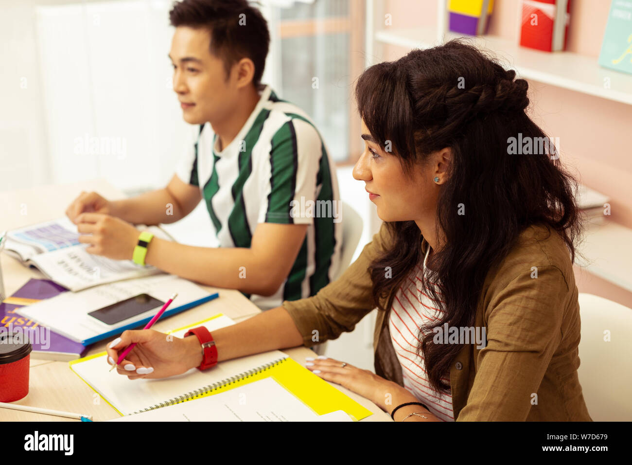 Positive delighted students making notes during lesson Stock Photo - Alamy