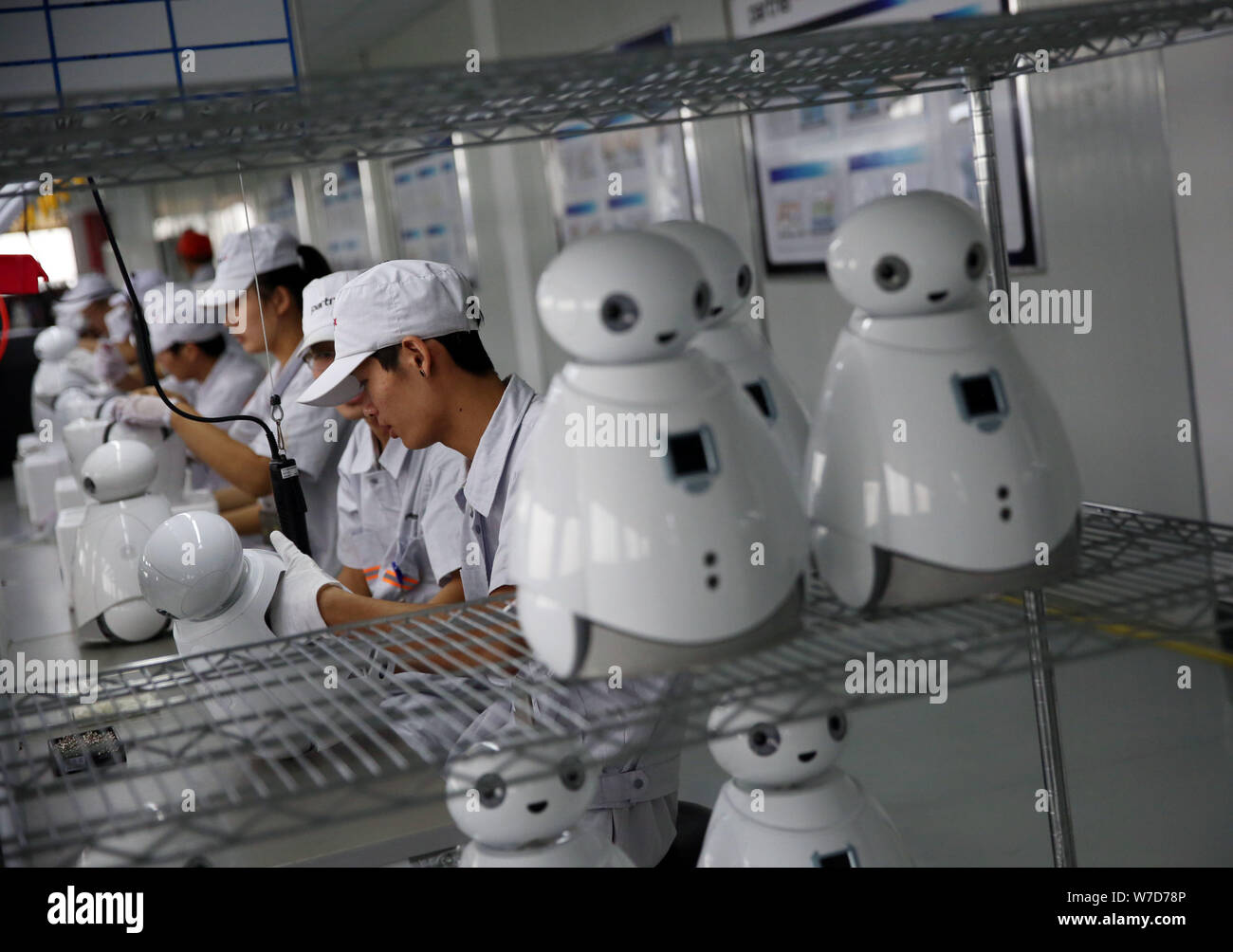 Chinese workers produce robots on the assembly line at China's largest ...