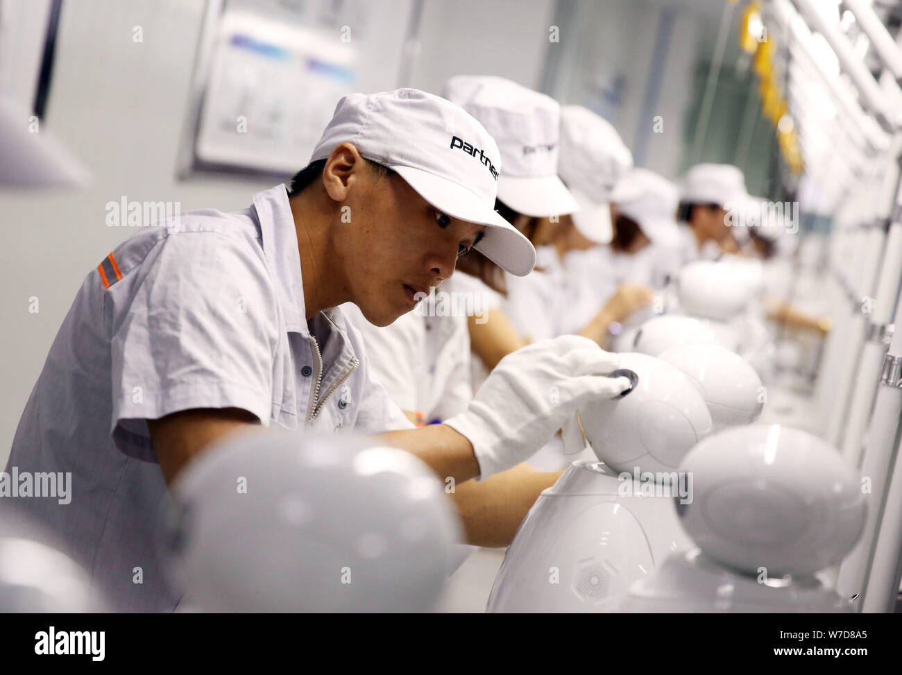 Chinese workers produce robots on the assembly line at China's largest ...