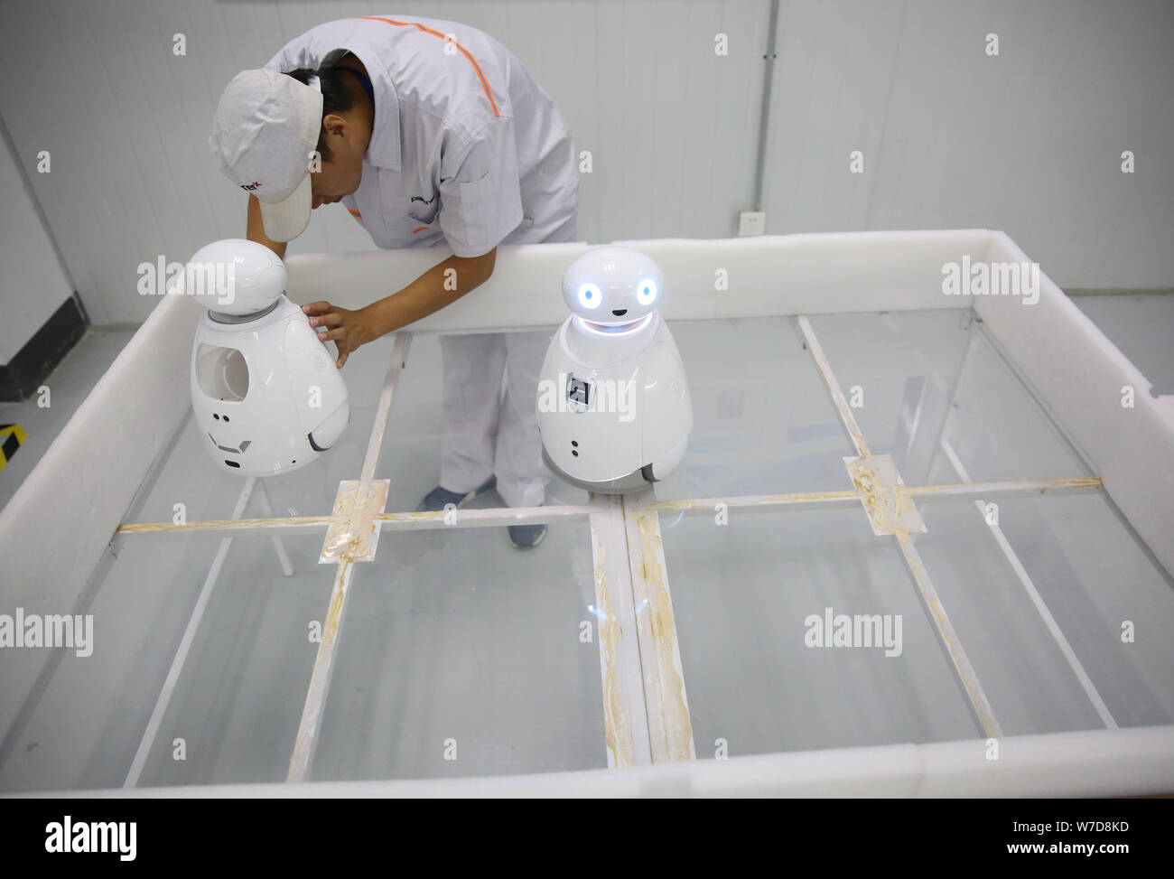 A Chinese worker produces robots on the assembly line at China's ...