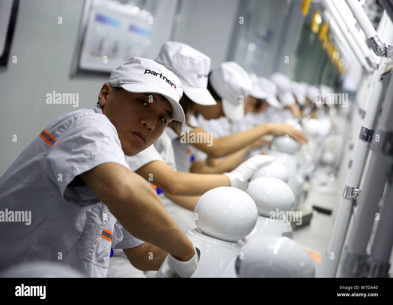 Chinese workers produce robots on the assembly line at China's largest ...