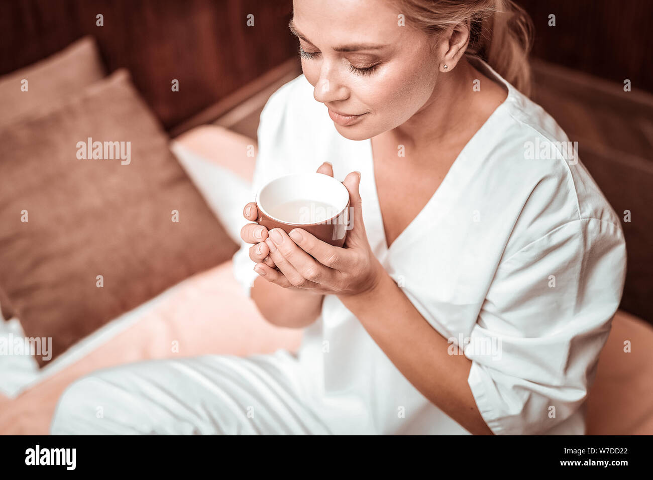 Beautiful woman enjoying the flavour of her tea Stock Photo - Alamy