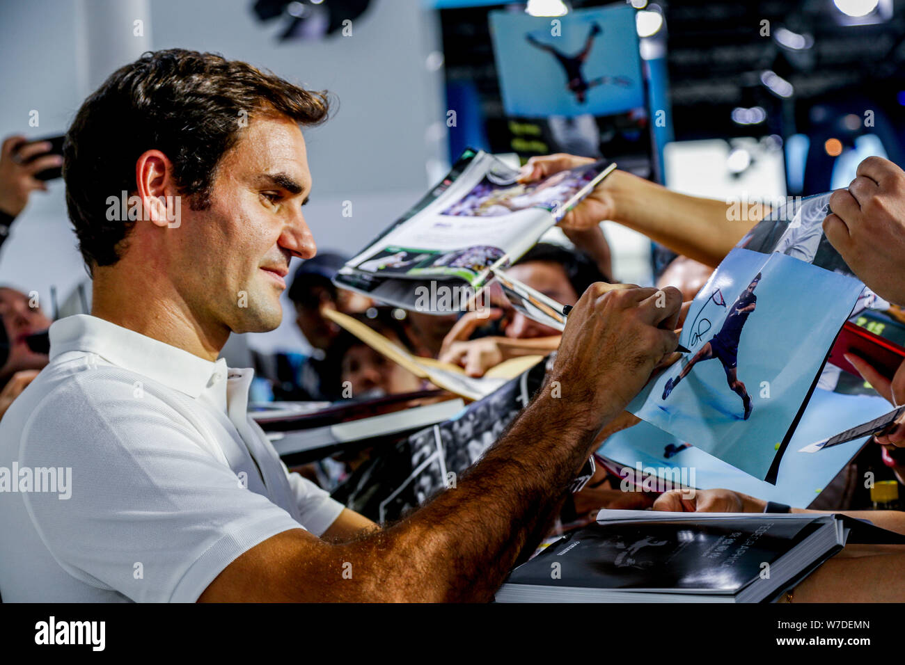 Swiss tennis player Roger Federer signs autographs for fans at a ...