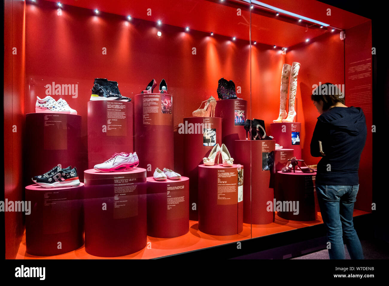 A visitor looks at pairs of shoes on display duirng the "Shoes ...