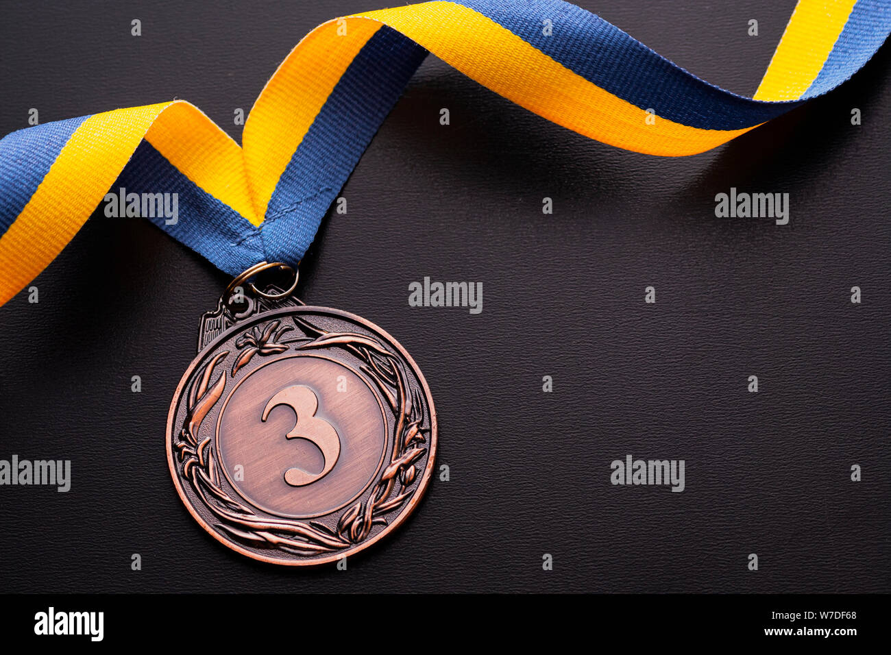 Third placed runner up bronze medal for a competition on a twirled blue ...