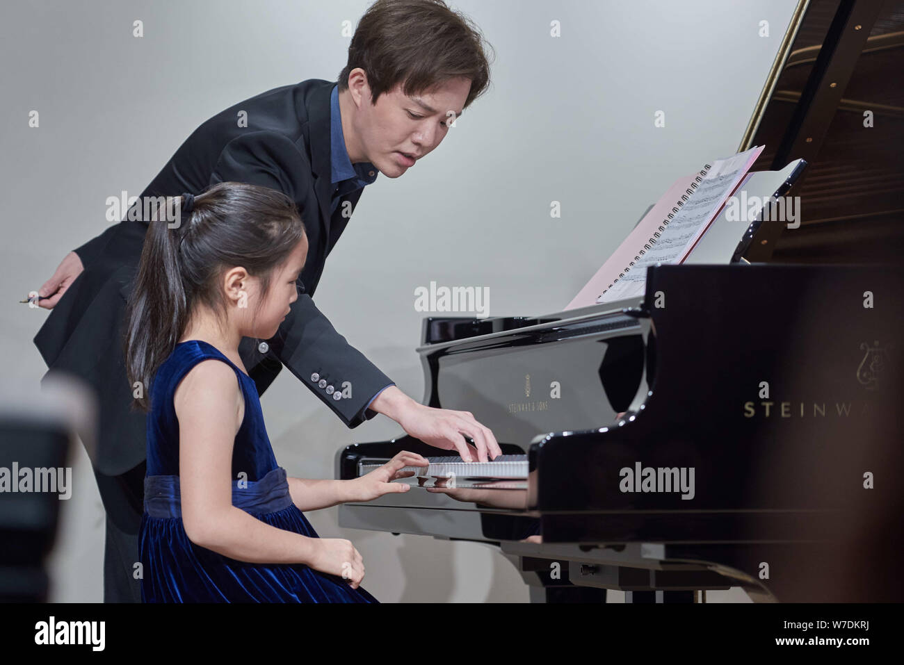 Chinese pianist Li Yundi instructs an enthusiast to play the piano at ...