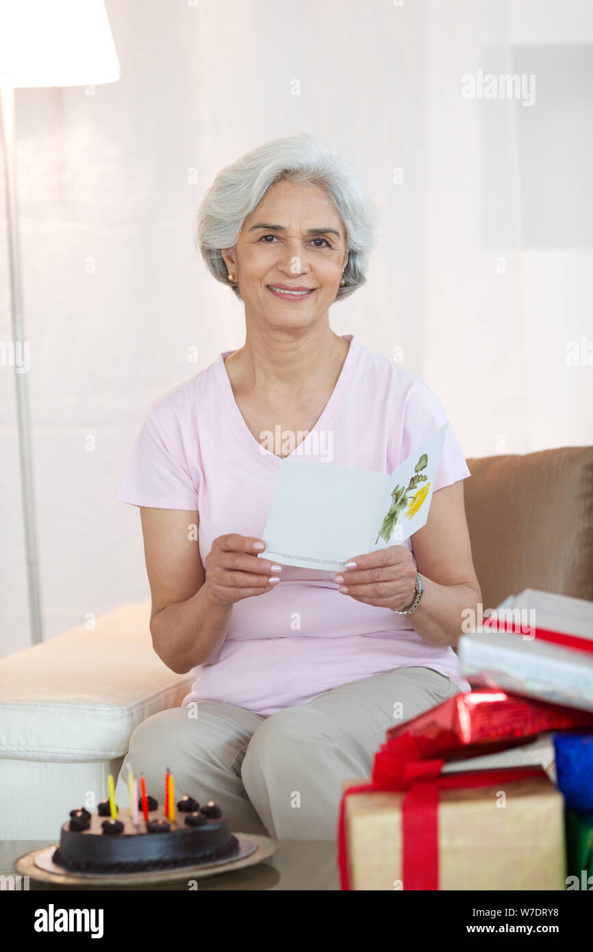 Old woman holding greeting card with birthday cake Stock Photo - Alamy