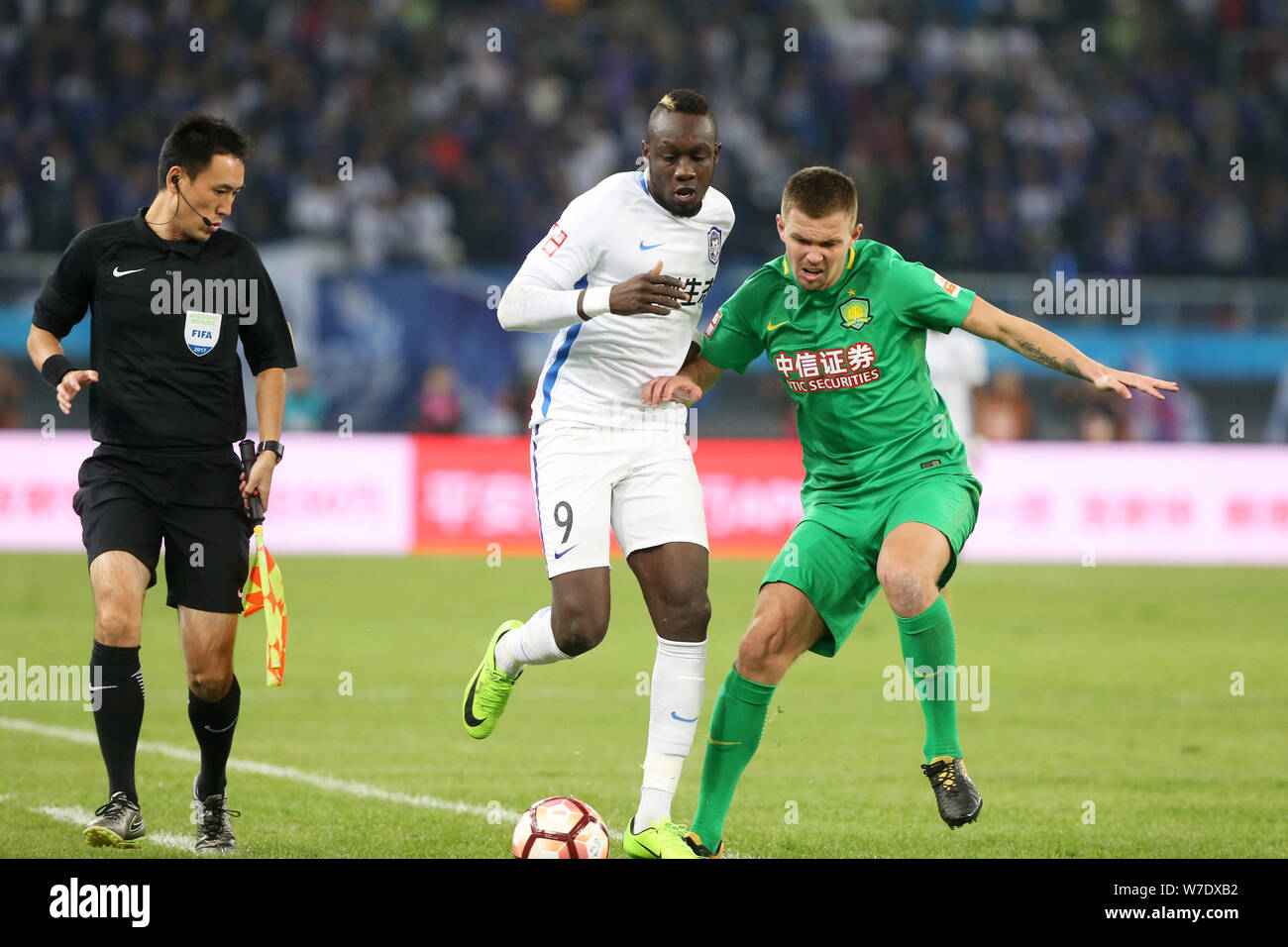 Senegalese football player Mbaye Diagne, left, of Tianjin TEDA kicks ...