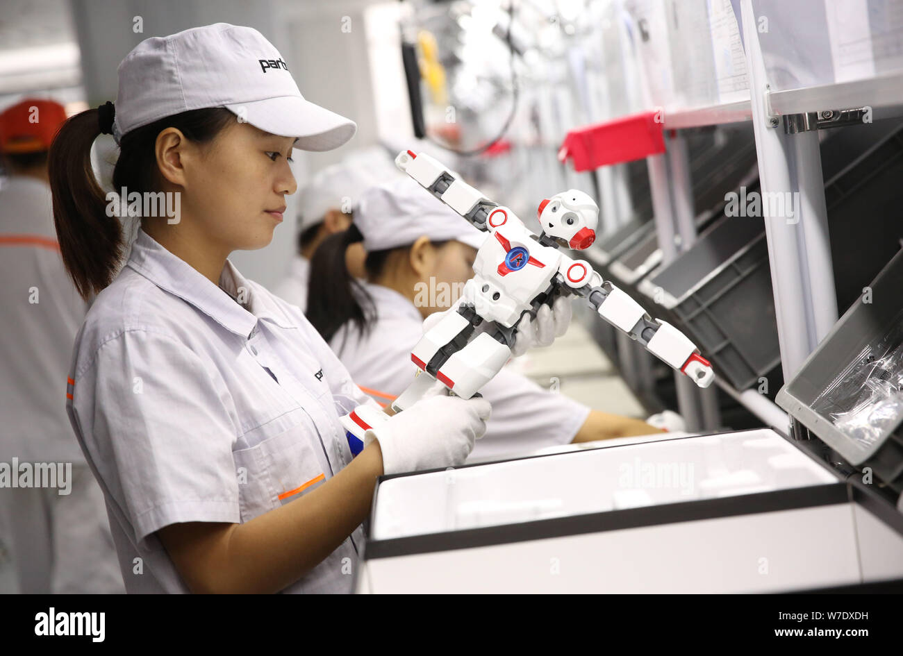 Chinese workers produce robots on the assembly line at China's largest ...