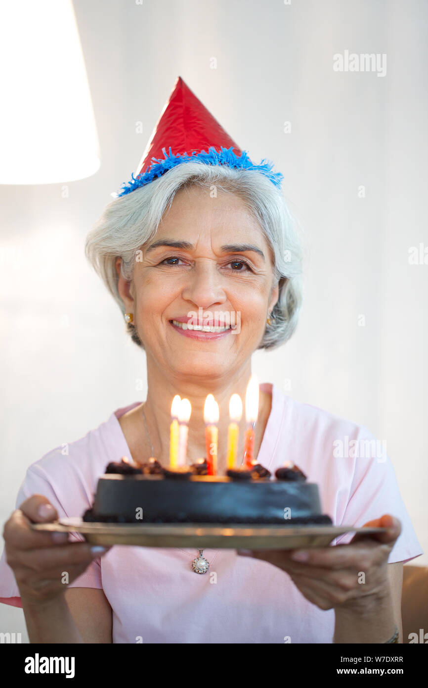 Senior woman holding birthday cake hi-res stock photography and images ...