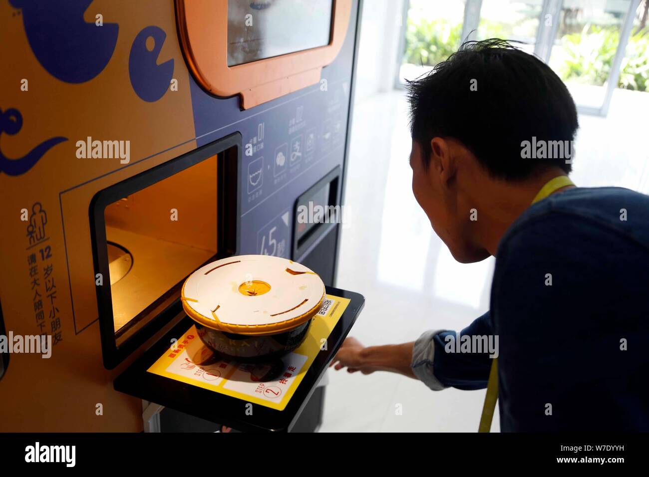 A customer gets his noodles from a mobile self-service noodle vending machine of Yo-Kai Express ...