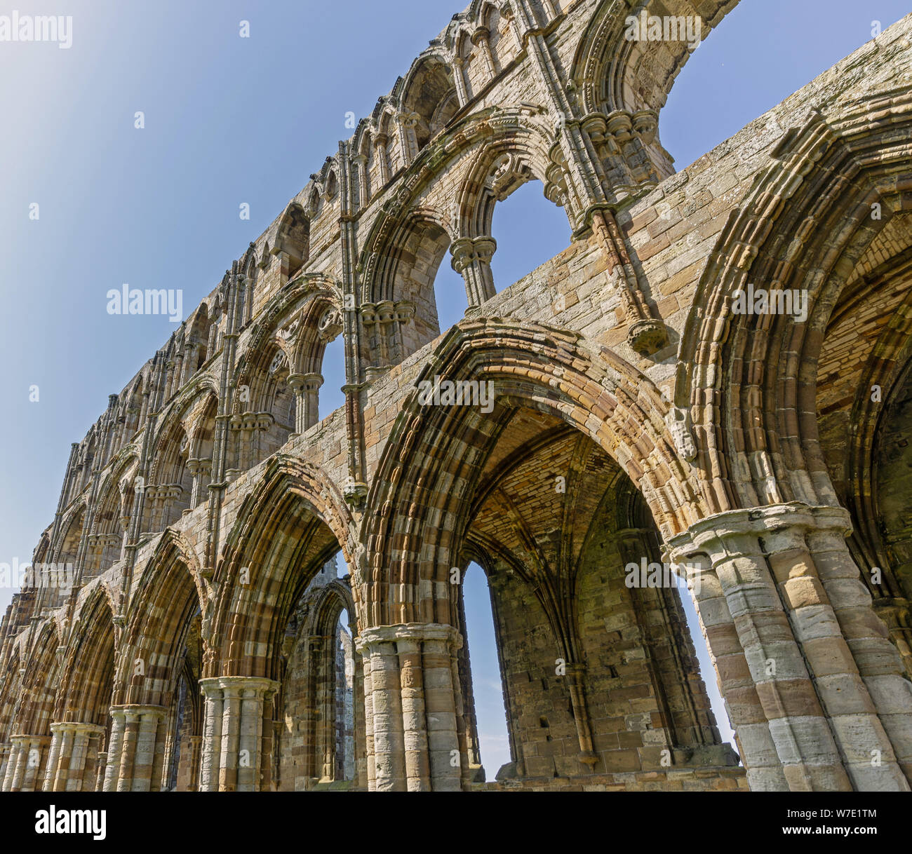 The arches and columns of Whitby Abbey standing against the sky. The ...