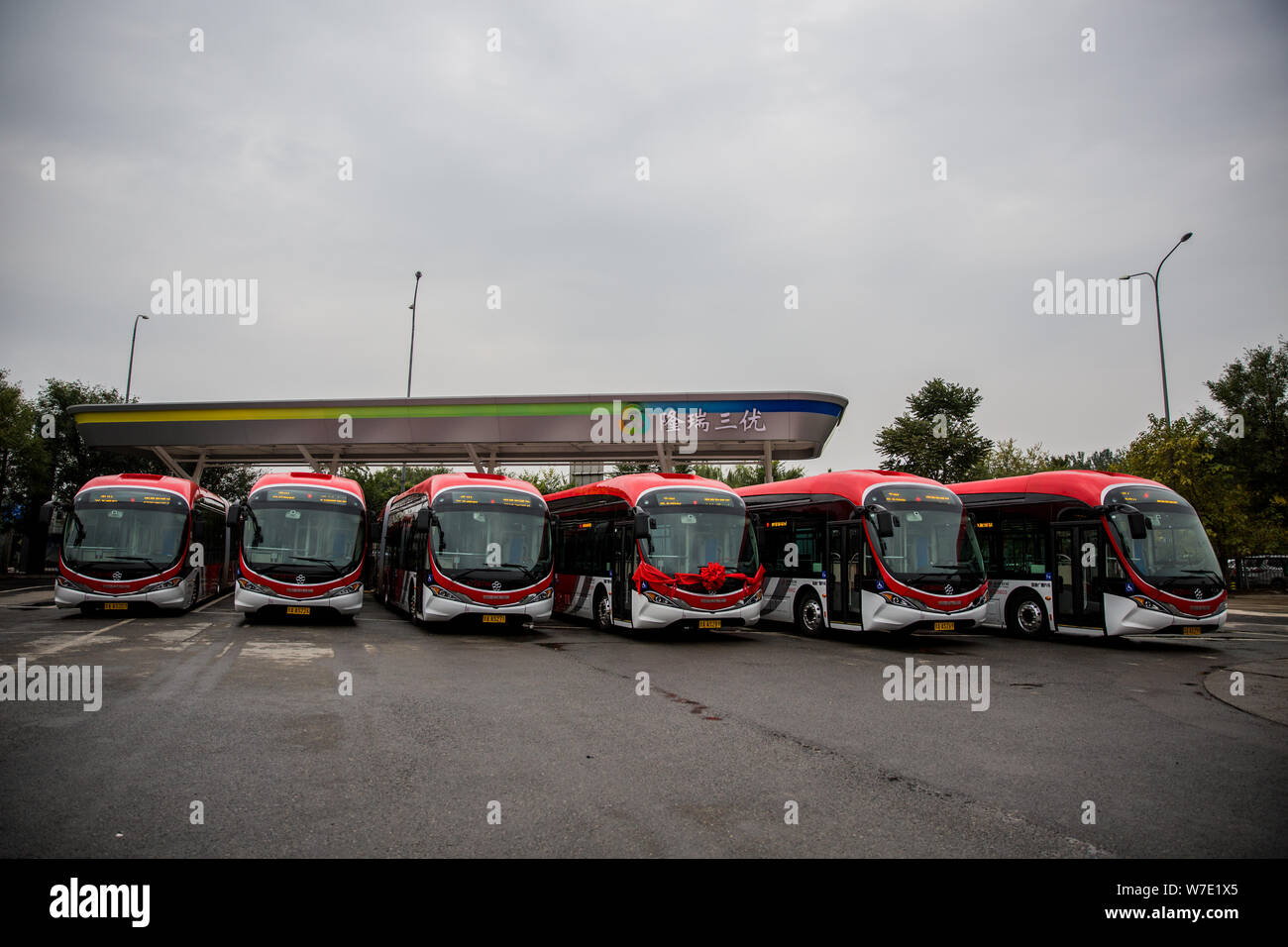 The first batch of 10 electric buses in red are lined up at a charging ... The first batch of 10 electric buses in red are lined up at a charging ...