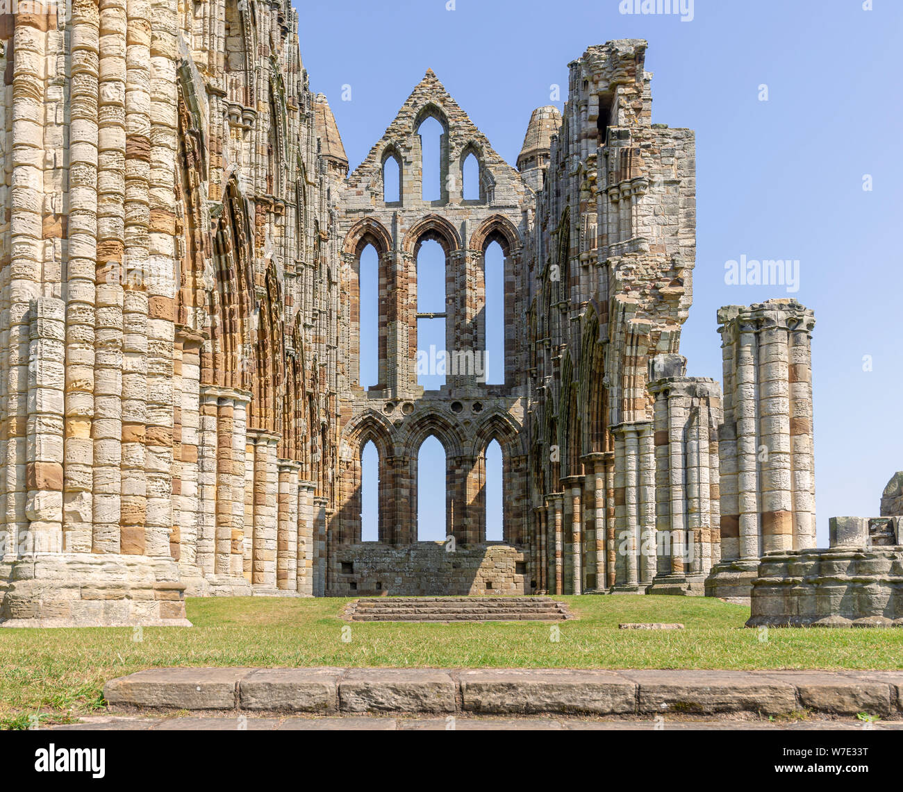 The arches and columns of Whitby Abbey in perspective. The sun falls on ...