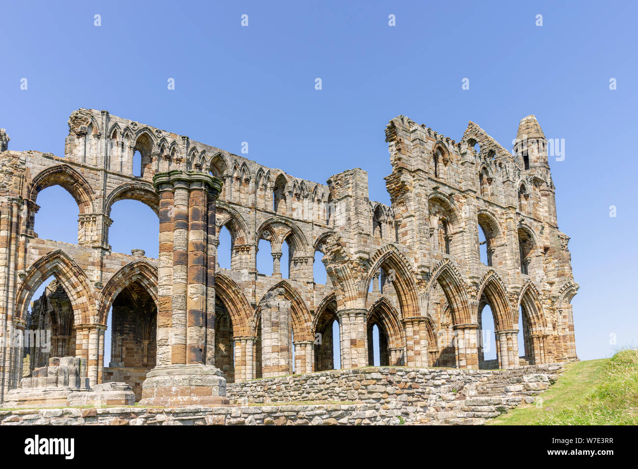 The arches and columns of Whitby Abbey in perspective. The sun falls on ...