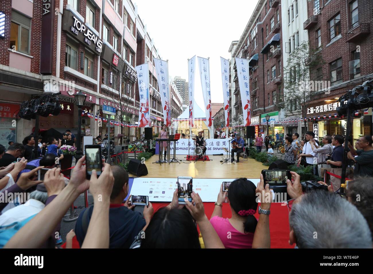Chinese vistiors look at a French brand performing at the street market ...