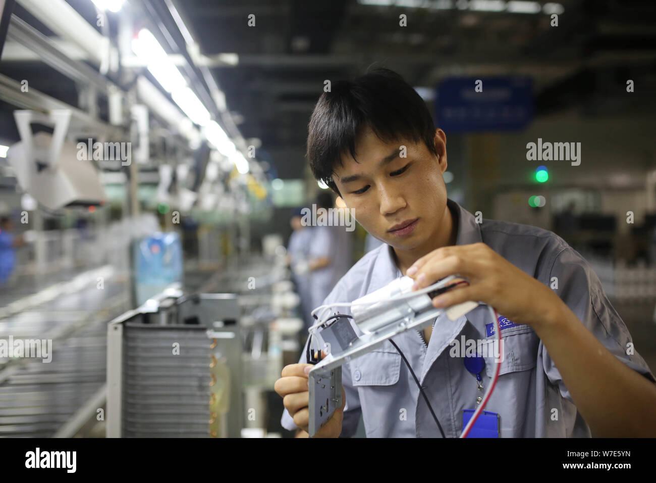 --FILE--A Chinese worker checks a component of air-conditioners on the ...