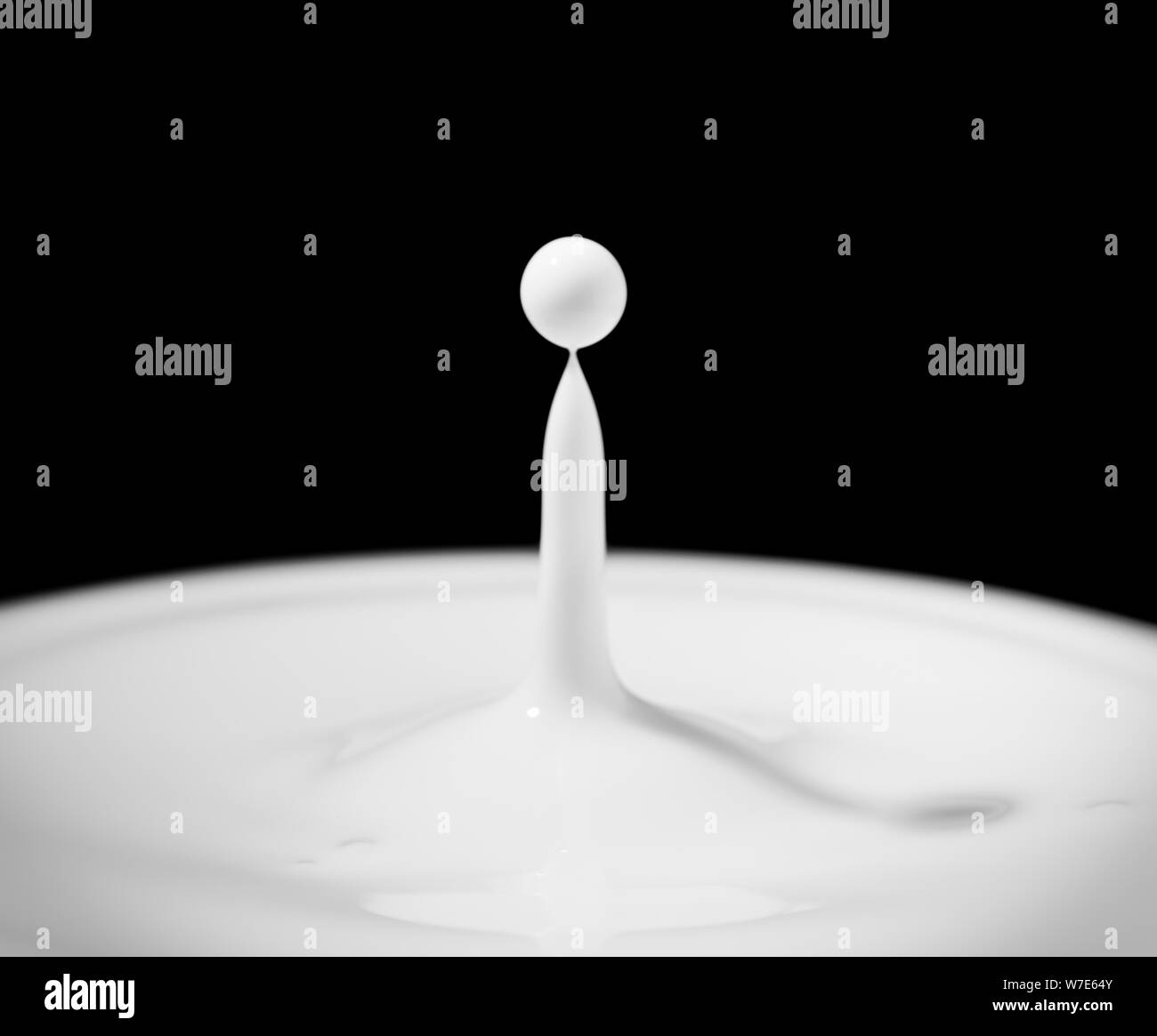 Drop of milk - milk droplet falling on white liquid and creating splash ...